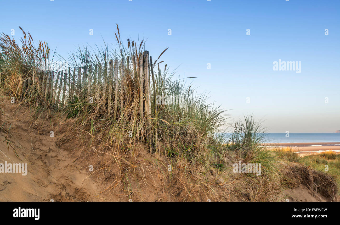 Stunning sunrise over sand dunes system on yellow sand golden beach ...