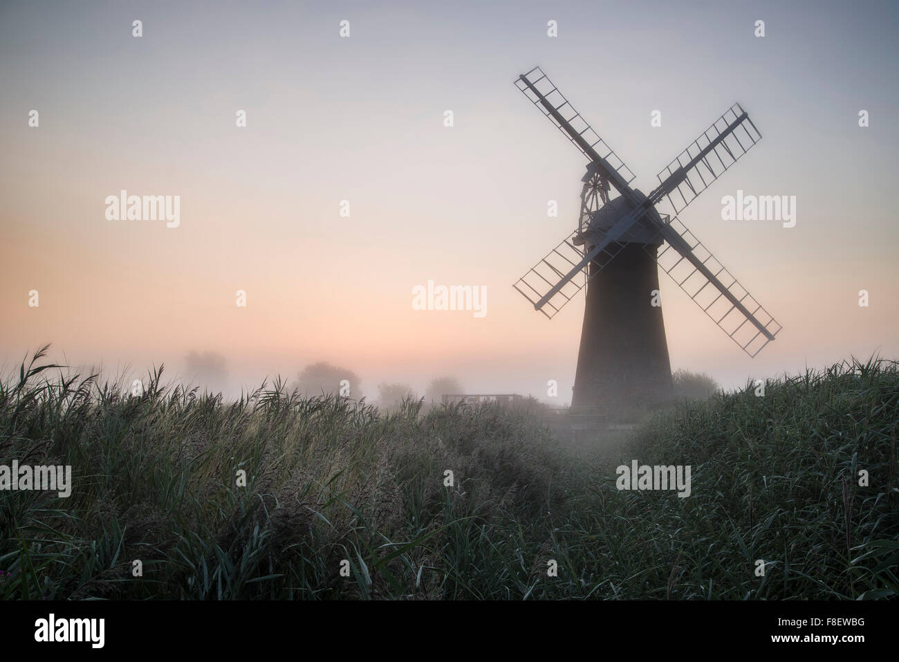 Windmill in stunning landscape on beautiful Summer sunrise Stock Photo ...
