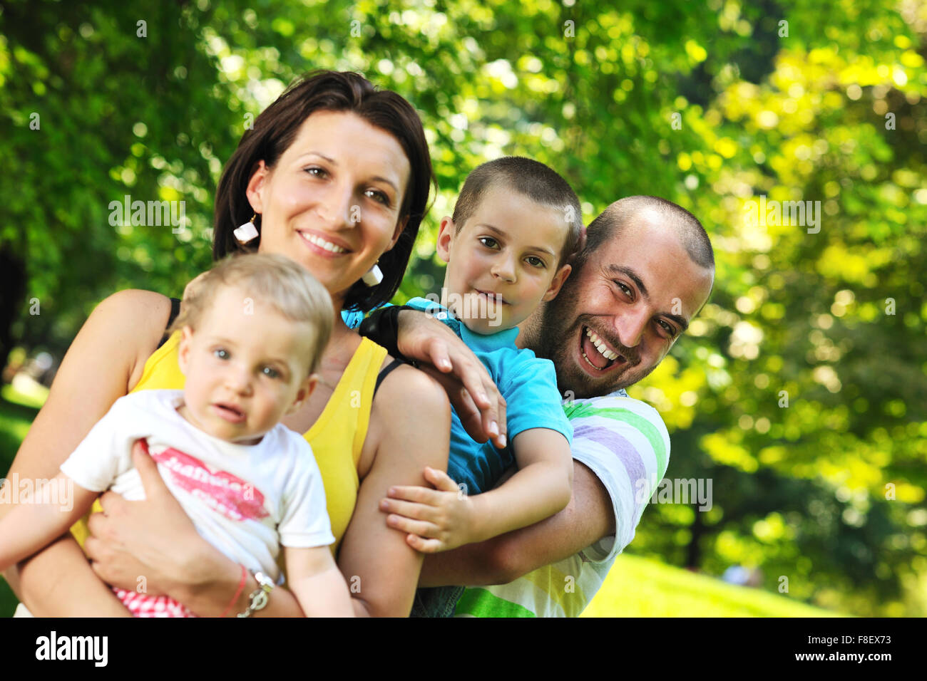 happy young couple with their children have fun at beautiful park ...
