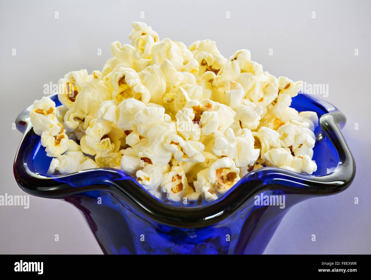 Closeup of homemade popcorn in blue glass on bright background Stock ...