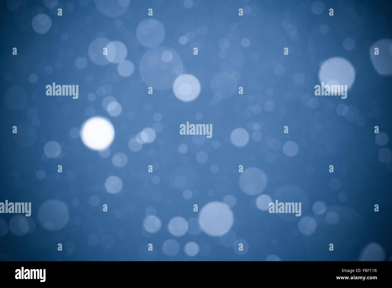 Falling snow on blue background Stock Photo - Alamy