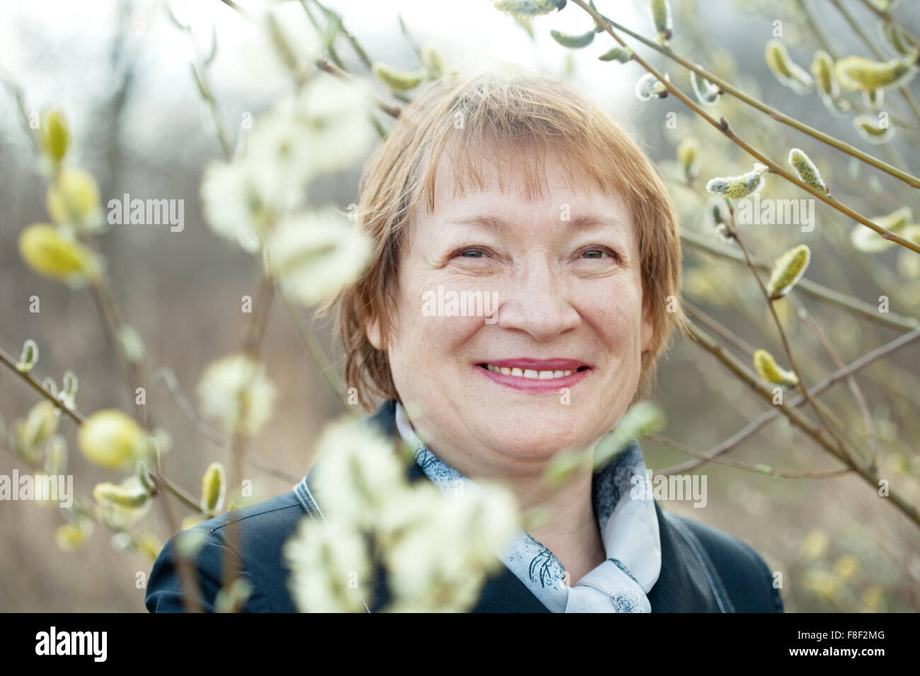 Smiling senior woman in spring willow twig with buds outdoor Stock ...
