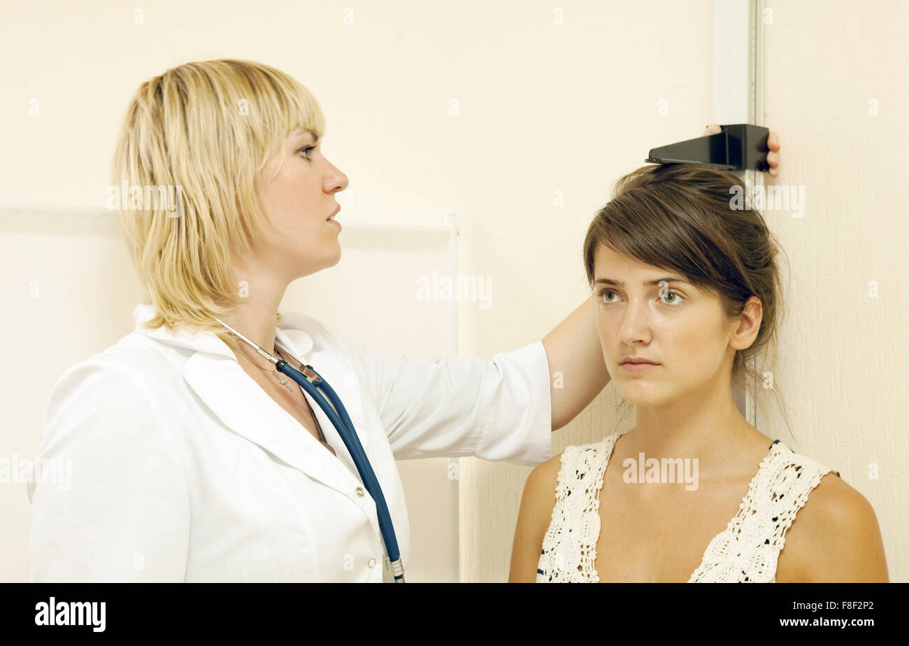 Woman measuring height of teenager patient in clinic Stock Photo - Alamy