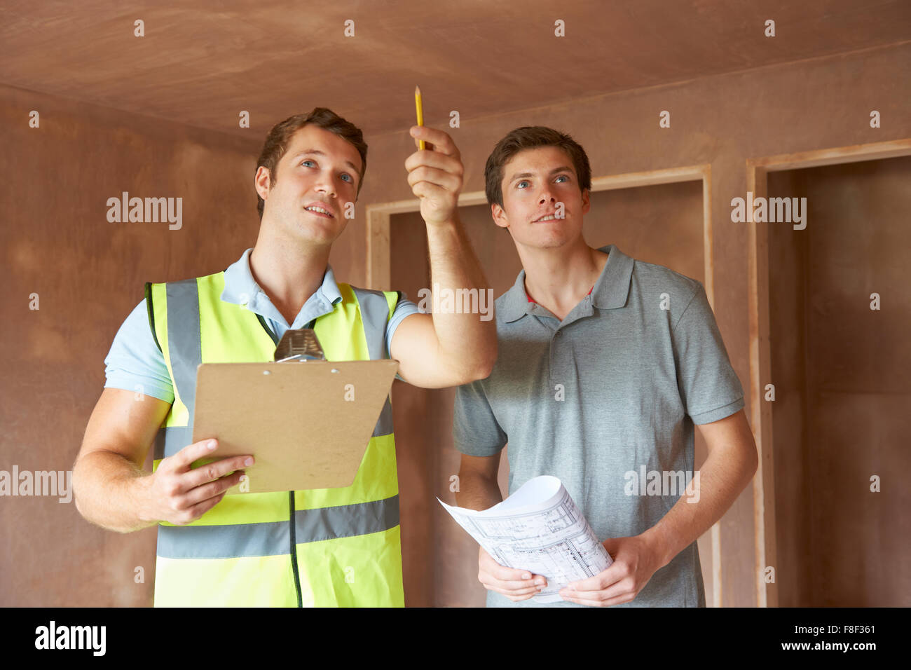 Builder And Inspector Looking At New Property Stock Photo - Alamy