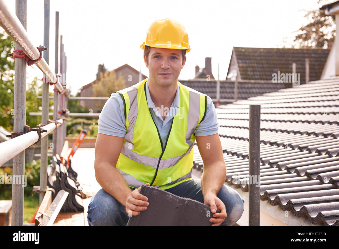 Builder Working On Roof Of New Building Stock Photo - Alamy