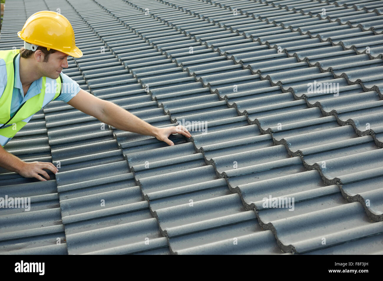 Builder Working On Roof Of New Building Stock Photo - Alamy