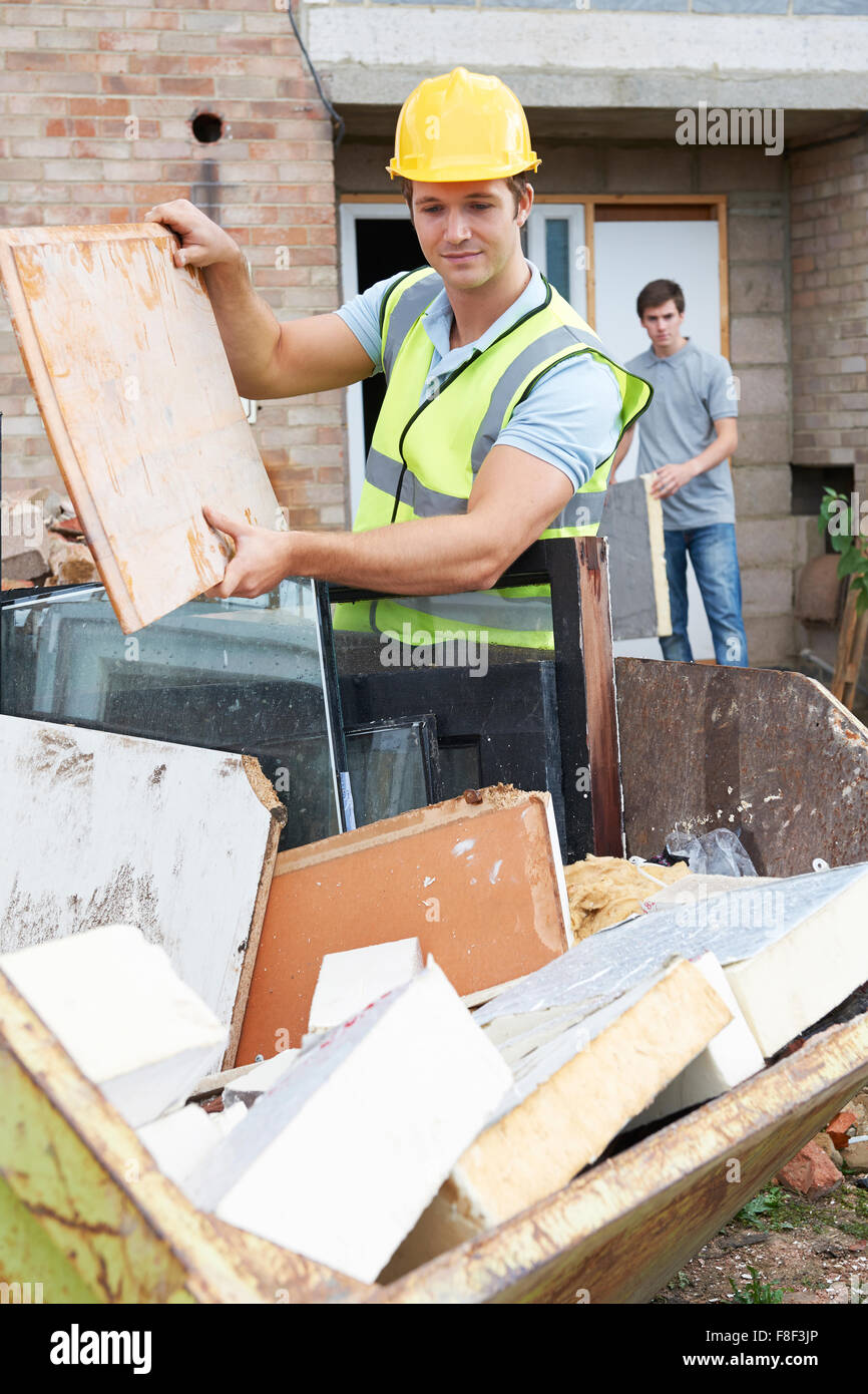 Builder Putting Waste Into Rubbish Skip Stock Photo - Alamy