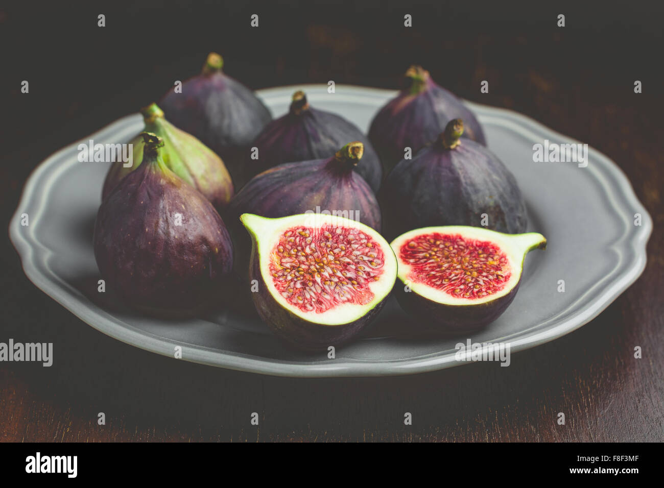 Fresh figs cut on a plate, close up, selective focus Stock Photo - Alamy