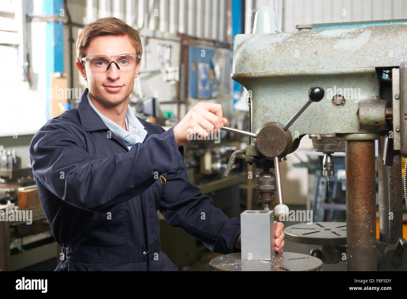 Engineer Using Drill In Factory Workshop Stock Photo - Alamy