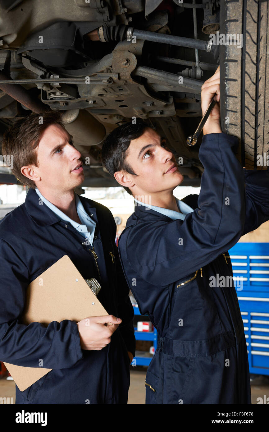 Mechanic And Trainee Working Under Car Stock Photo - Alamy