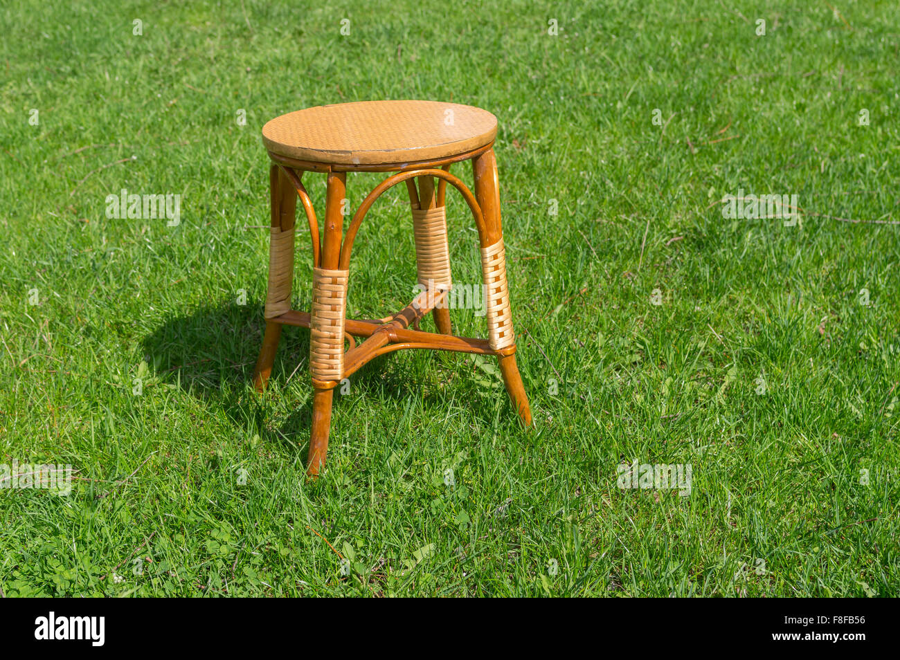 Used handmade wicker stool on a green spring grass Stock Photo - Alamy