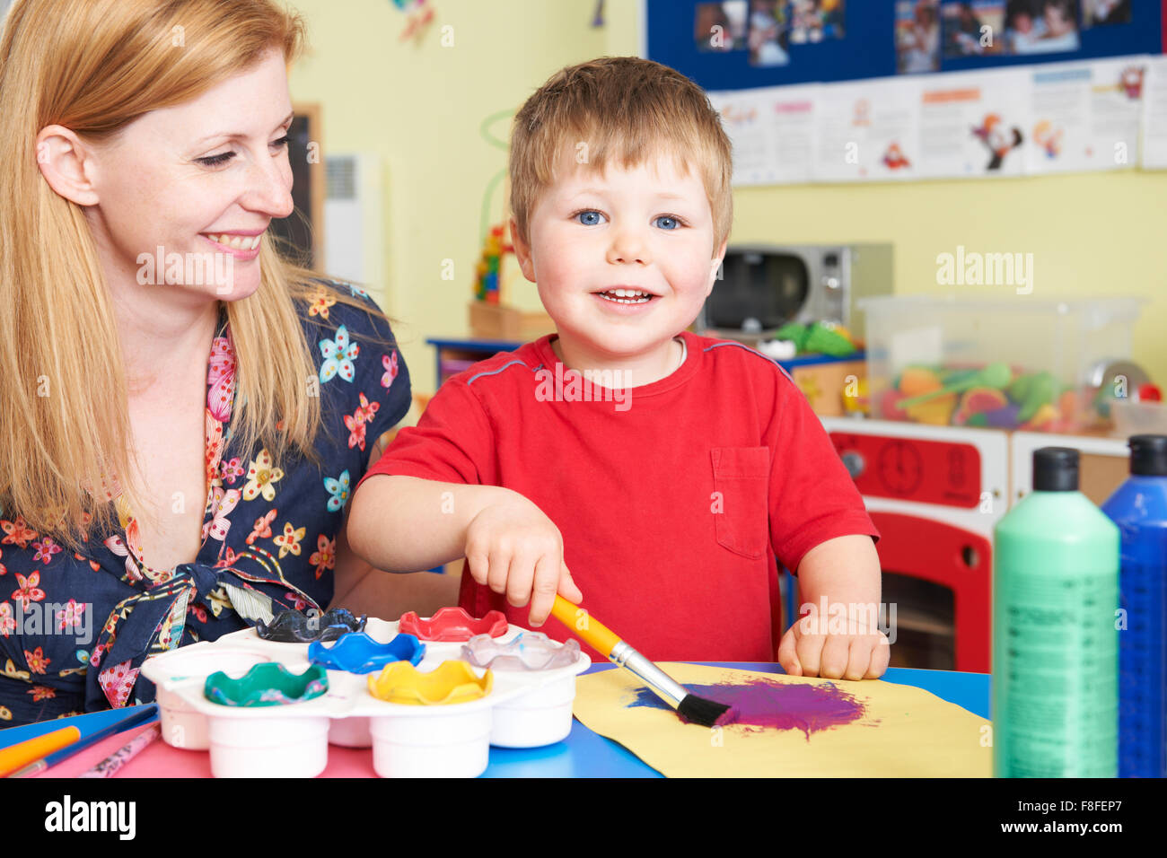 Teacher Helping Preschool Child In Art Class Stock Photo - Alamy