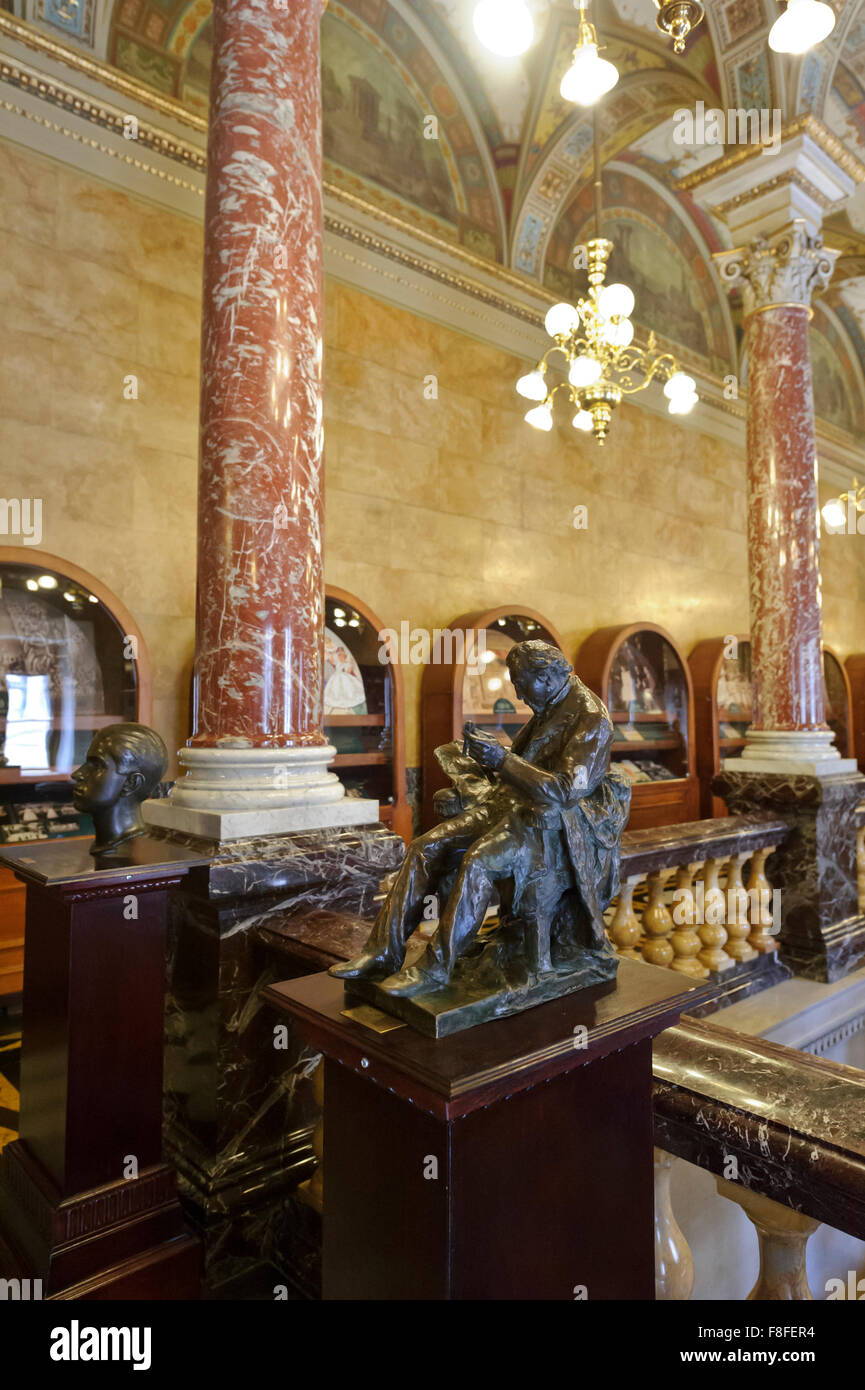 A small sculpture of a man sitting on a chair on the first floor of the ...