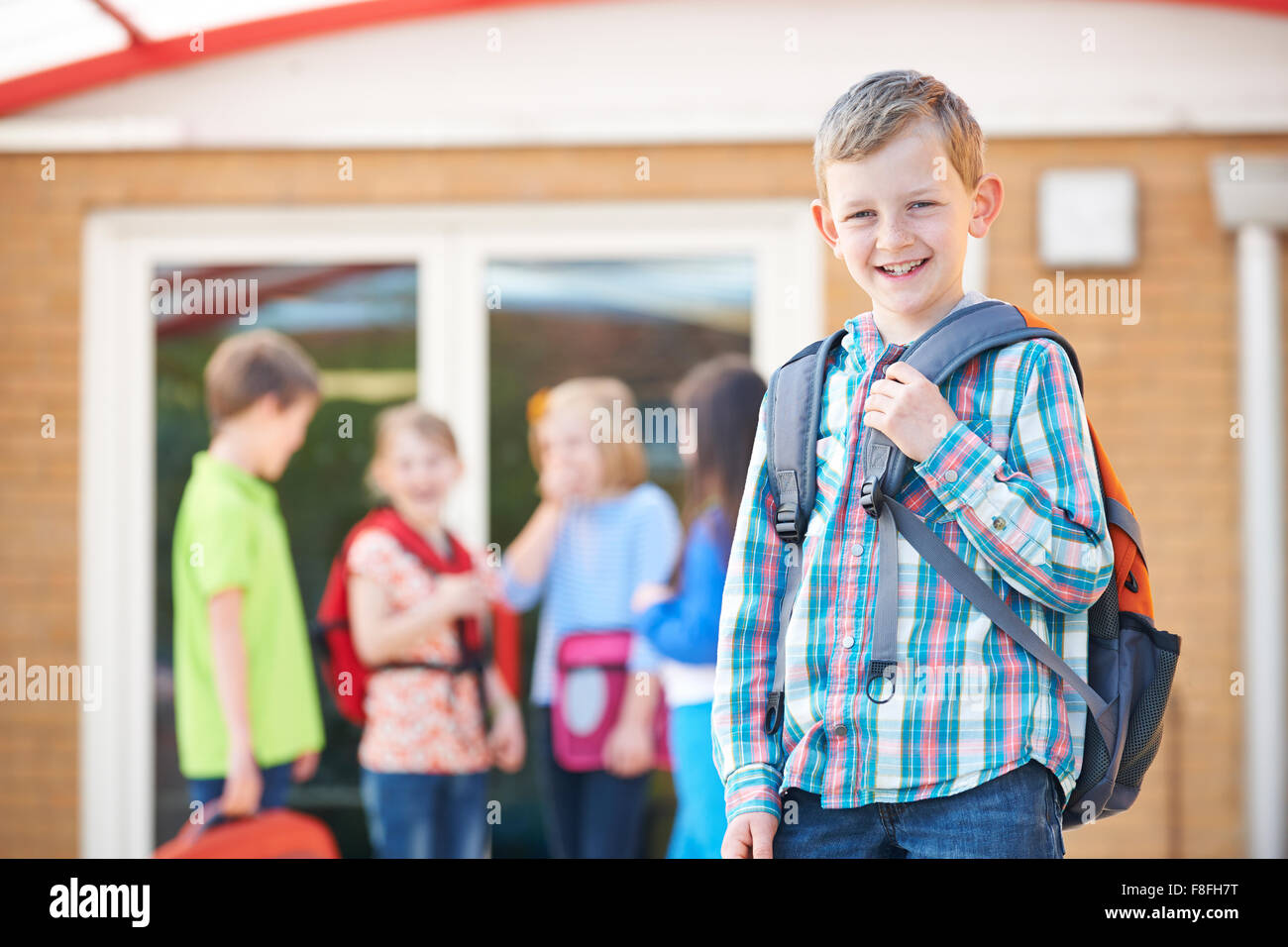 Boy Standing Outside School With Rucksack Stock Photo - Alamy