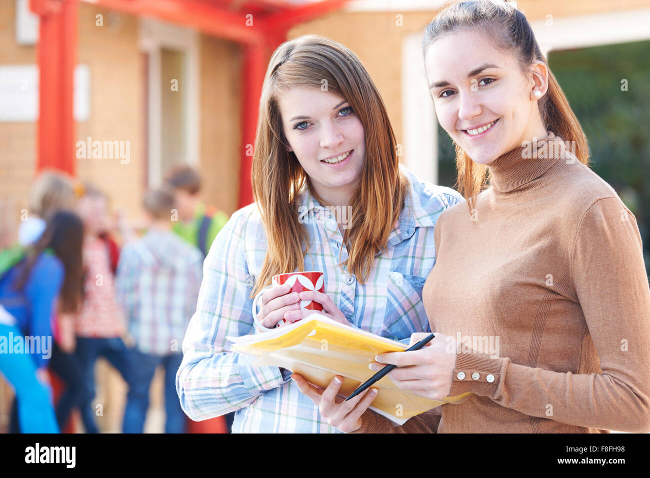 Two Teachers In Playground With Register At Break Time Stock Photo - Alamy