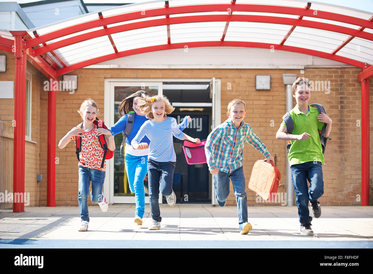 Schoolchildren Running Into Playground At End Of Class Stock Photo - Alamy