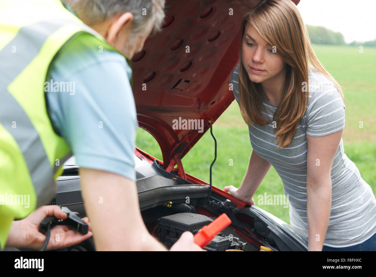 Mechanic Helping Female Motorist With Flat Battery Stock Photo - Alamy