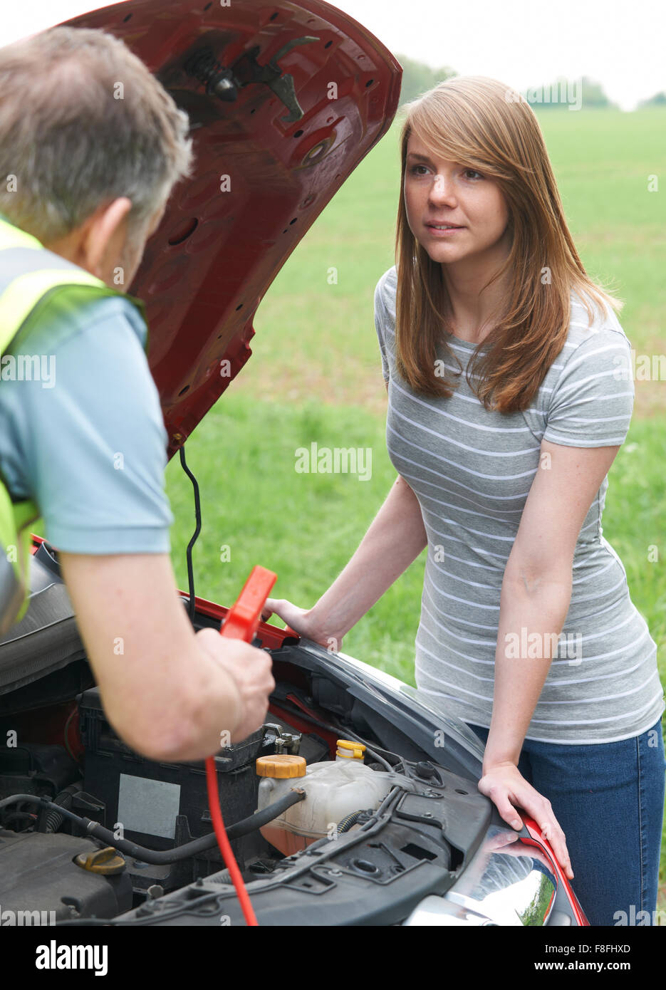 Mechanic Helping Female Motorist With Flat Battery Stock Photo - Alamy