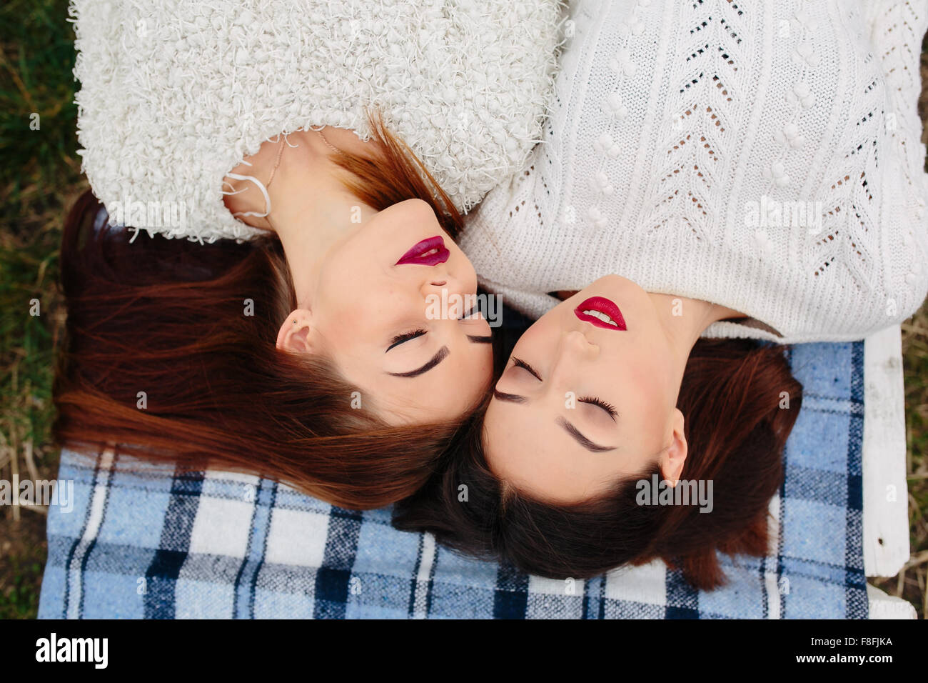 Two beautiful girls lie on the bench Stock Photo - Alamy