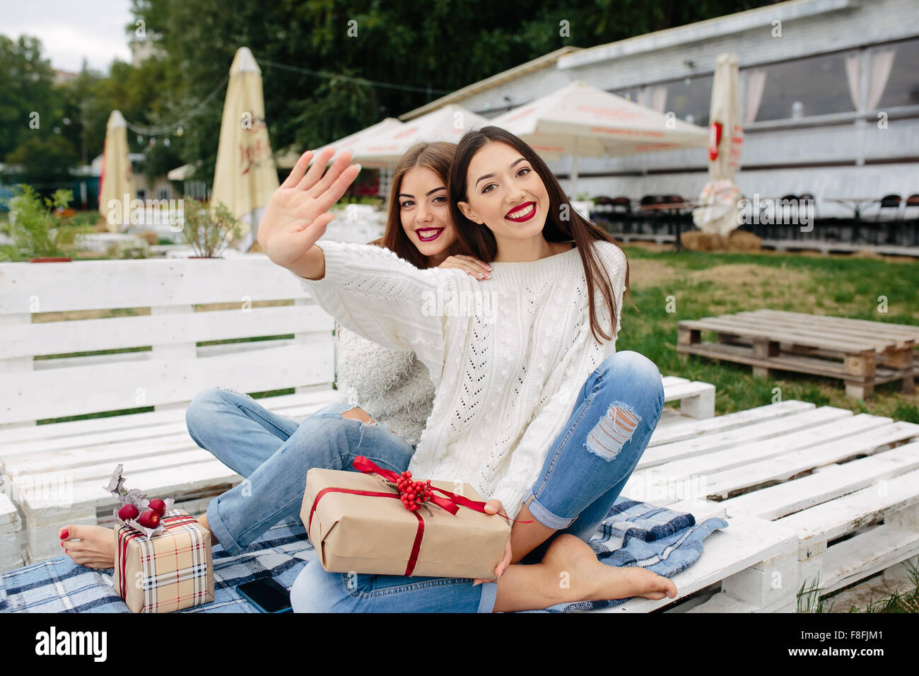 Two girls sitting outdoors on a bench hi-res stock photography and ...