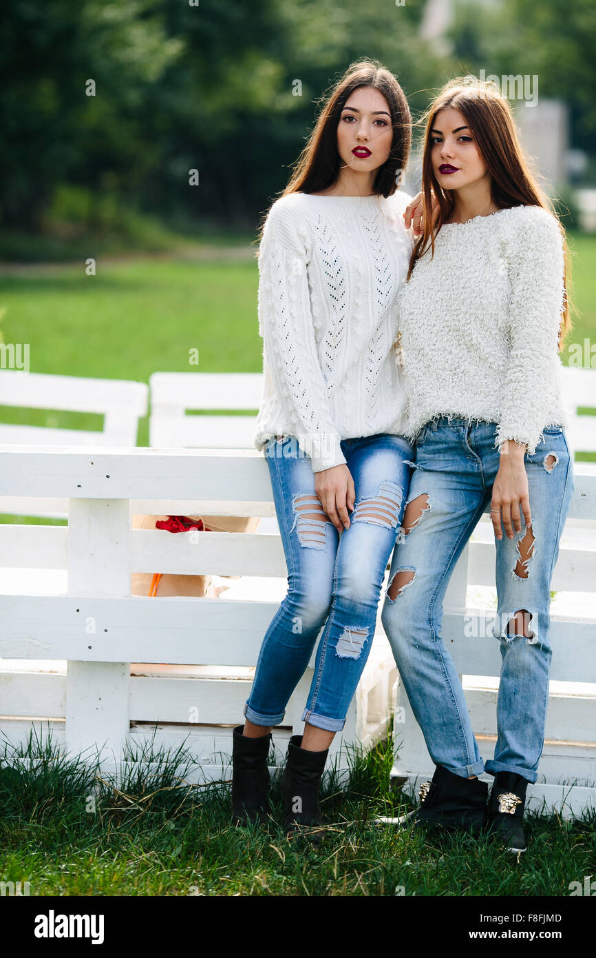 Two girls lean bench Stock Photo - Alamy