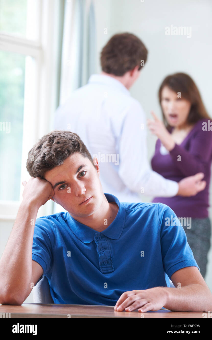 Unhappy Teenage Boy With Parents Arguing In Background Stock Photo - Alamy