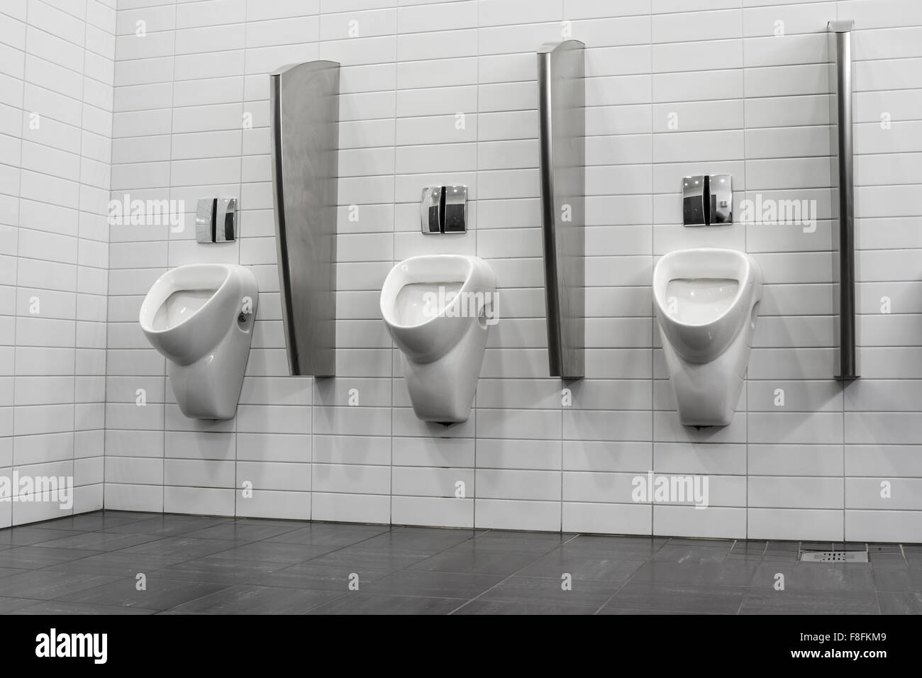 urinals in an new building for men only Stock Photo - Alamy