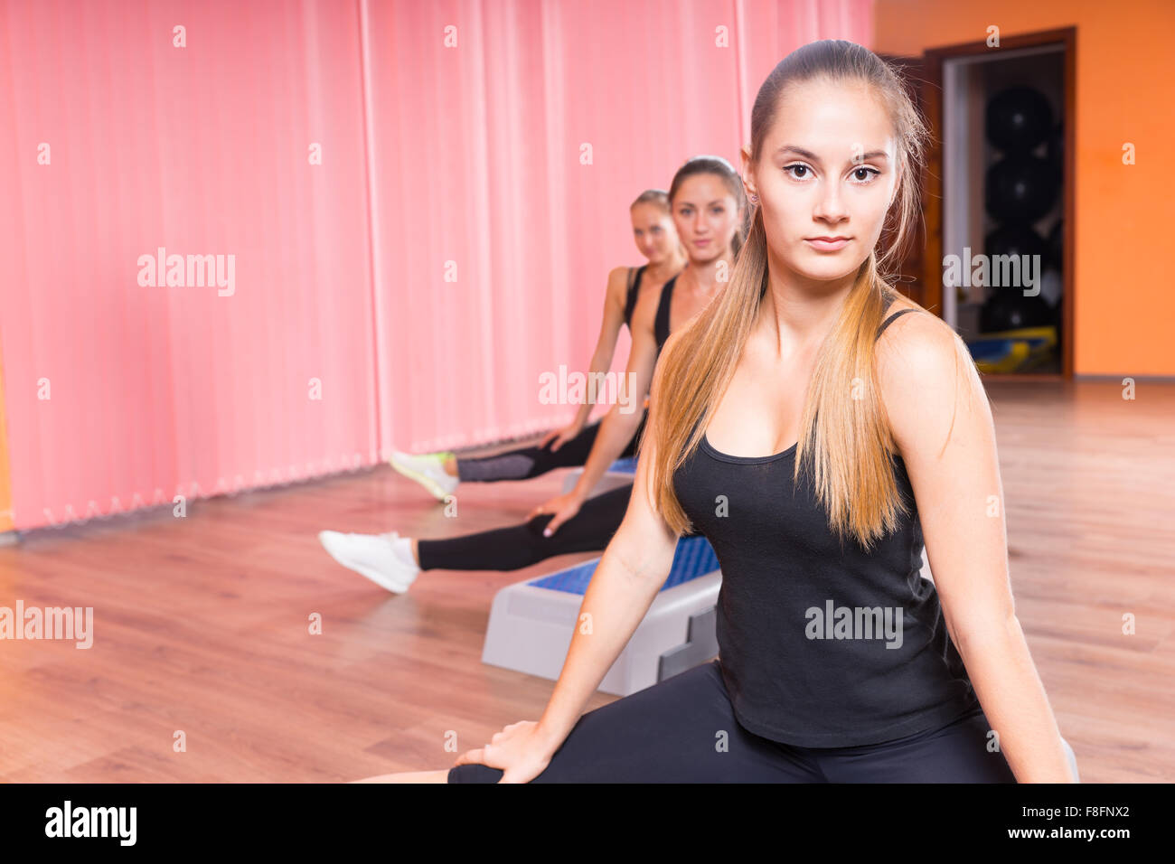 Three Young Athletic Women Sitting on Aerobic Step Platforms and ...
