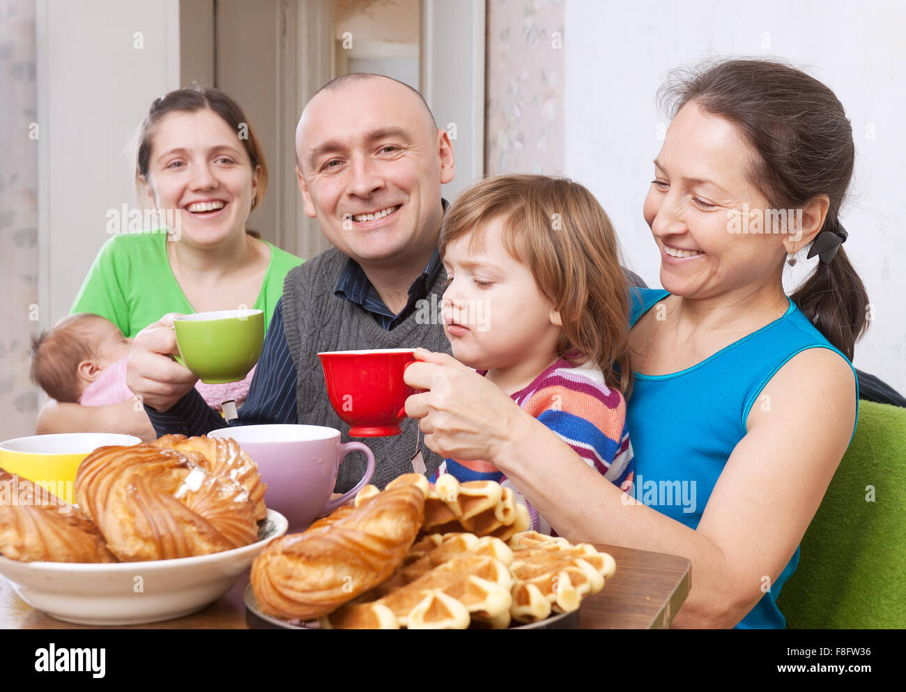 Happy family having tea and baked at home Stock Photo - Alamy