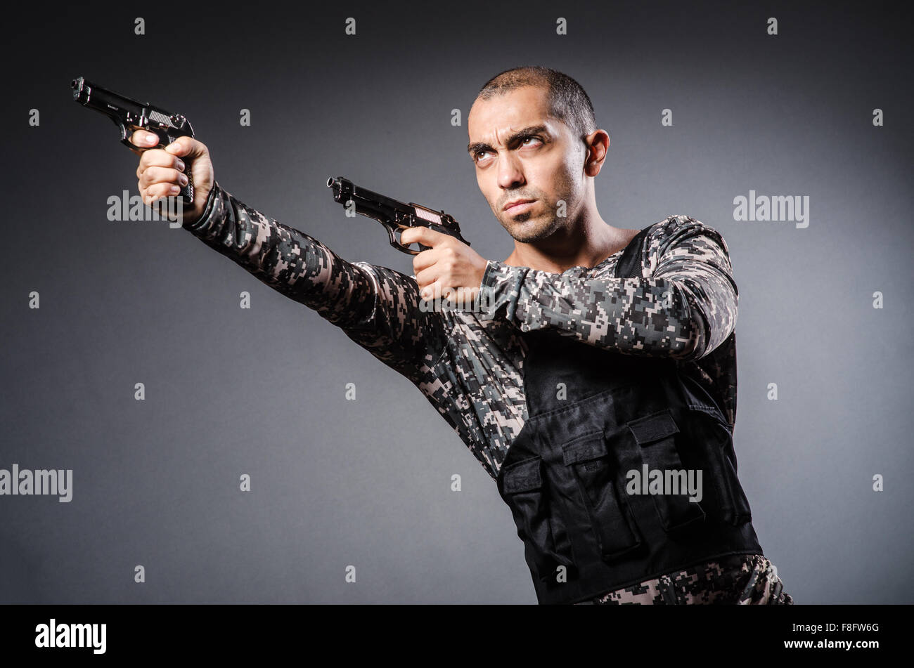 Soldier with guns against dark background Stock Photo - Alamy