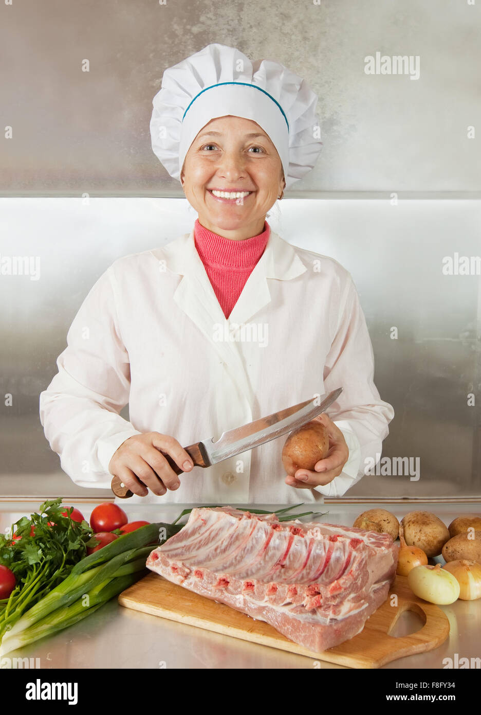 Cook woman cooking meat in kitchen Stock Photo - Alamy