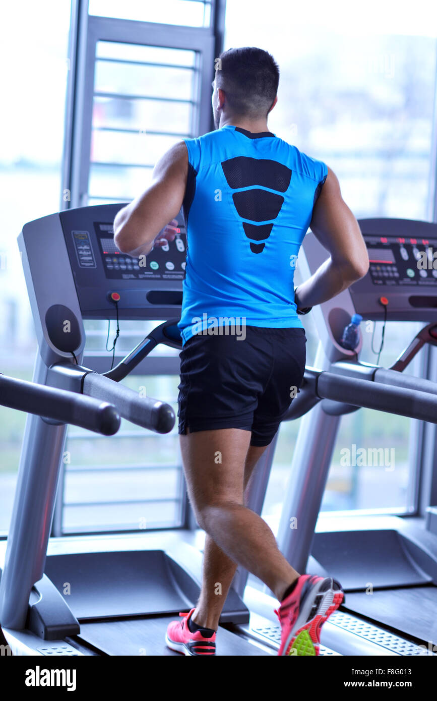 Handsome man running on the treadmill in modern gym Stock Photo - Alamy
