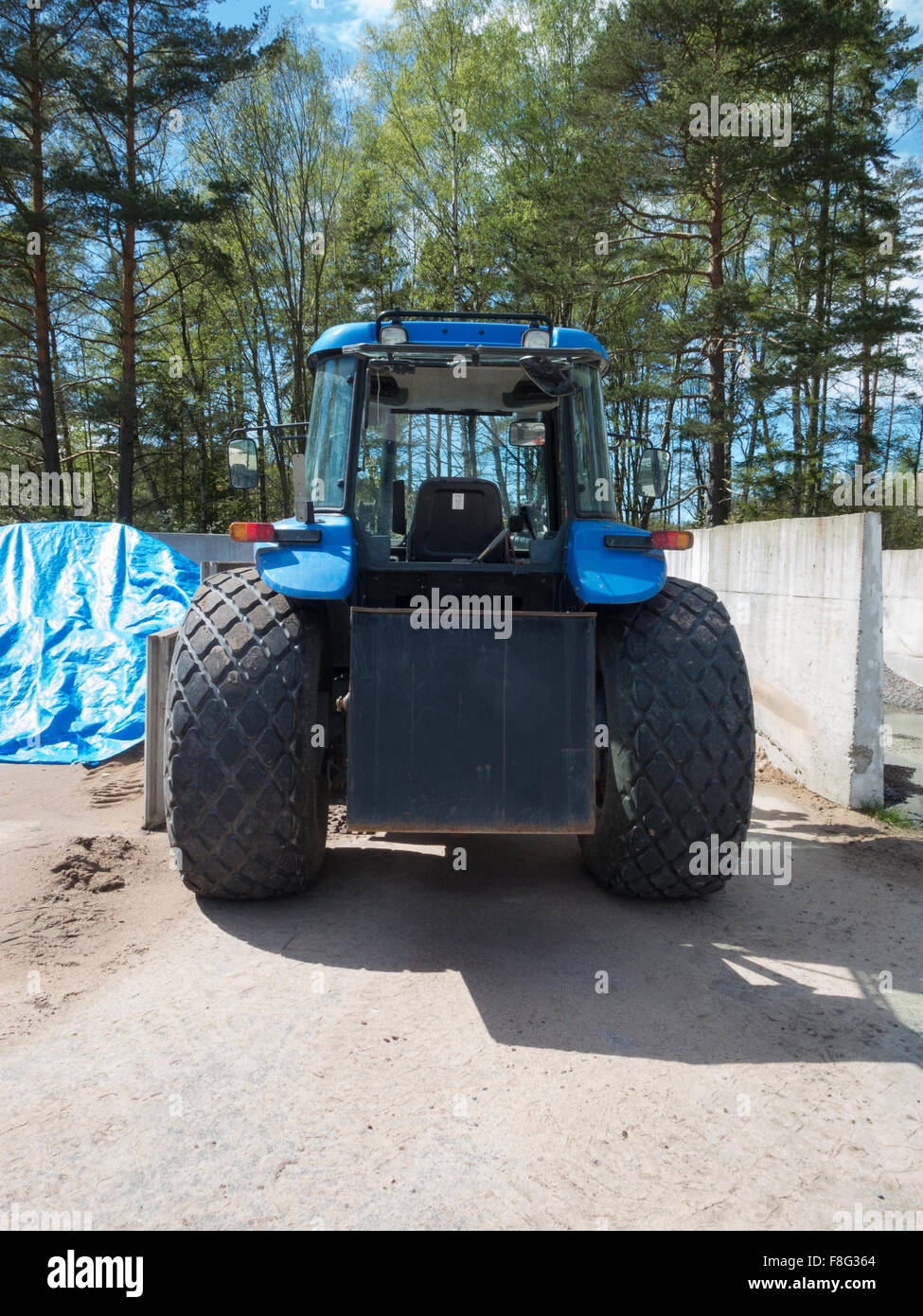 back of one big blue tractor with big wheel Stock Photo - Alamy