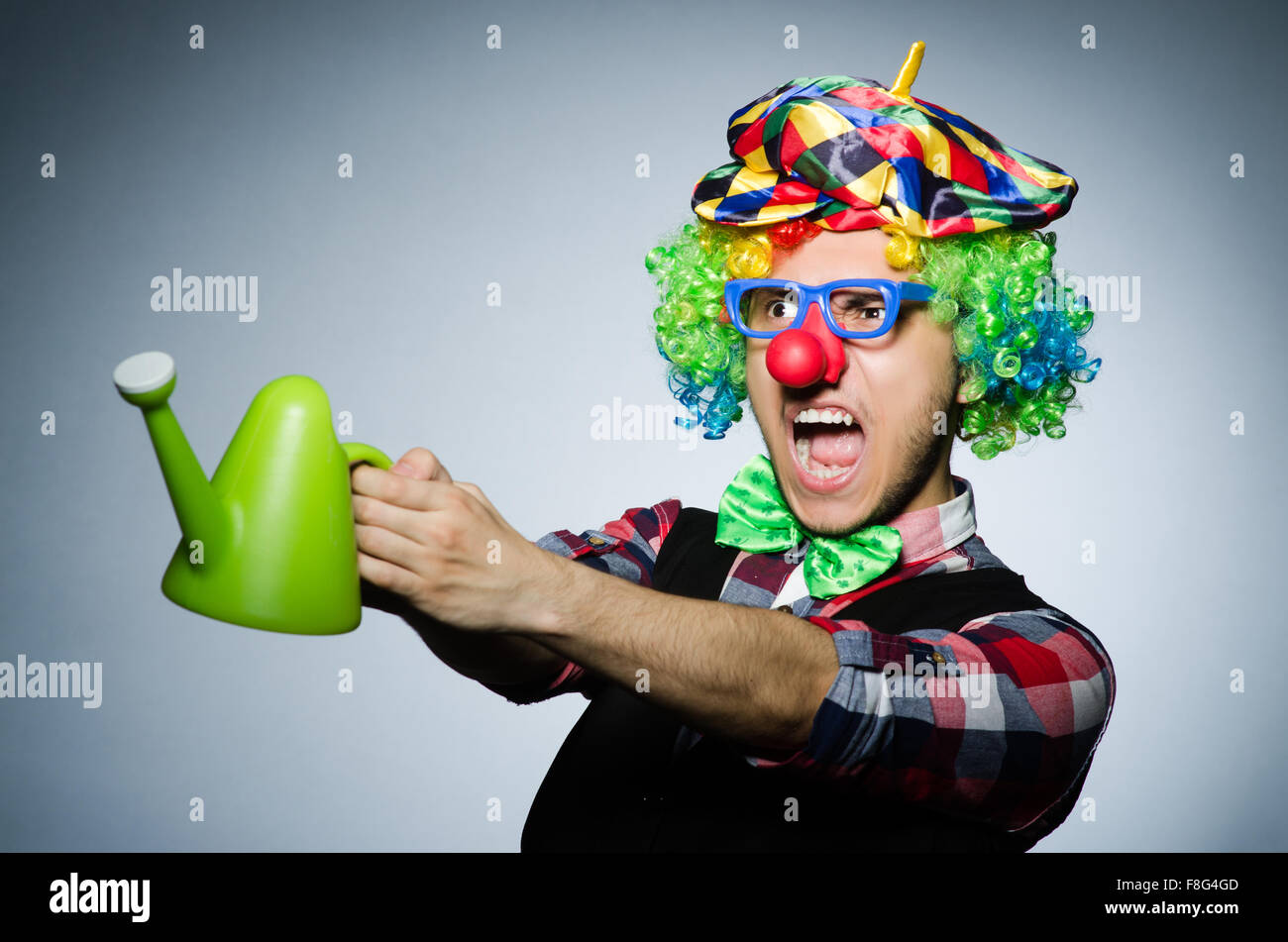 Funny clown with watering can Stock Photo - Alamy