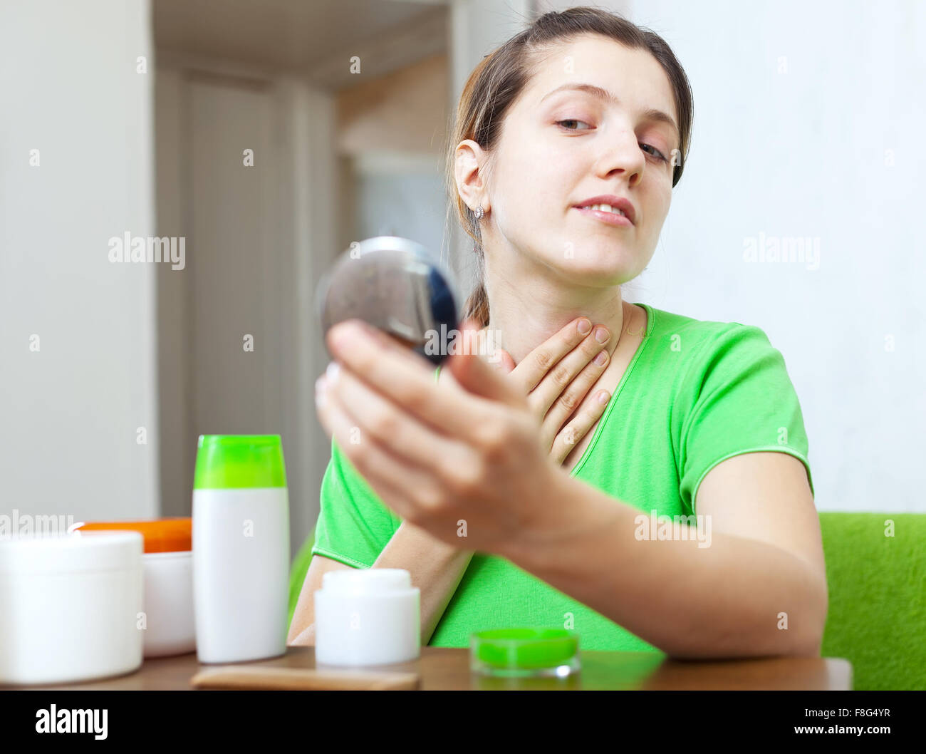 european woman stares on her neck in mirror at home Stock Photo - Alamy