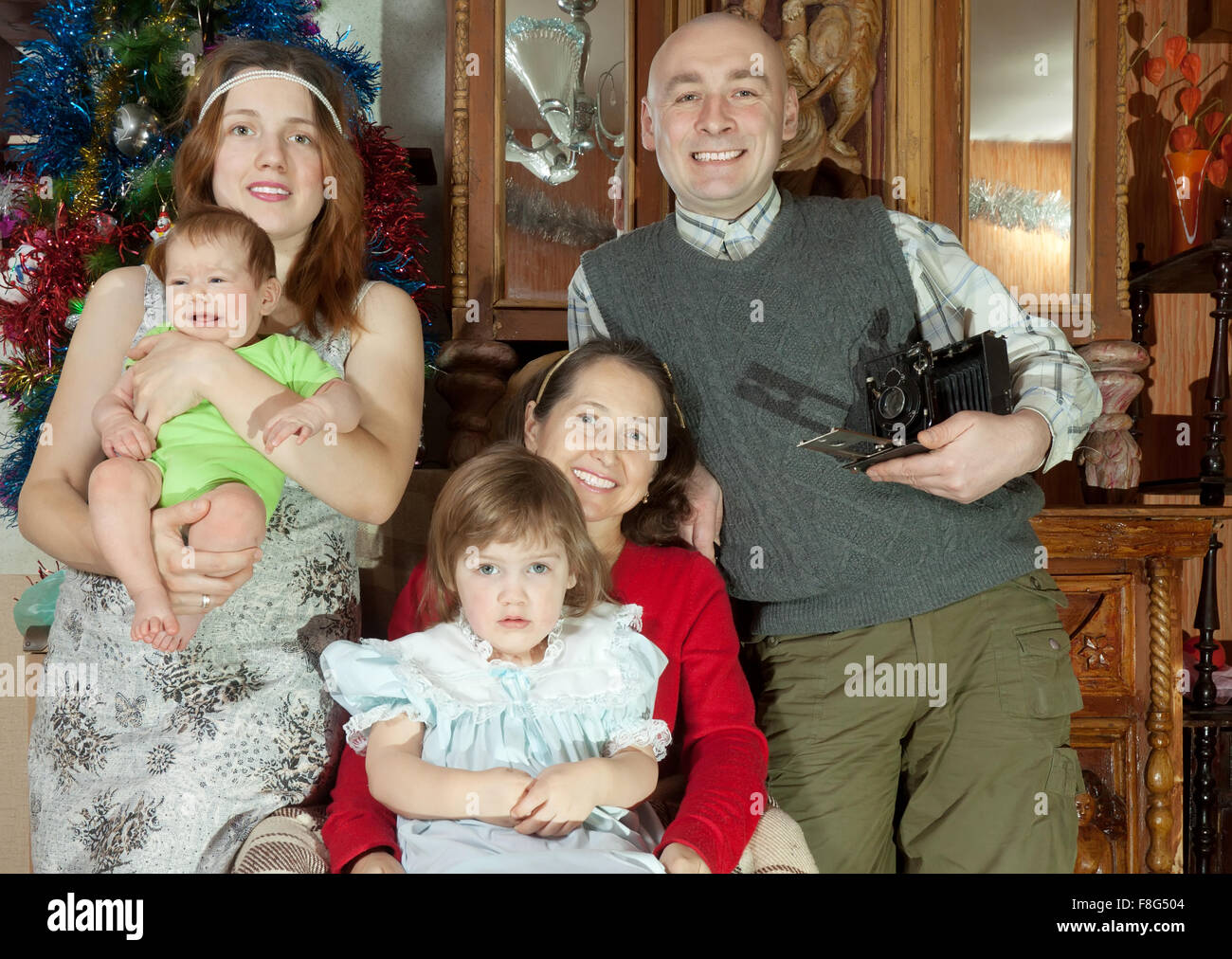 Portrait of happy three generations family of photographer at home ...