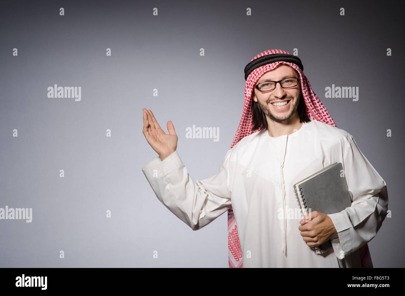 Arab student with book in education concept Stock Photo - Alamy