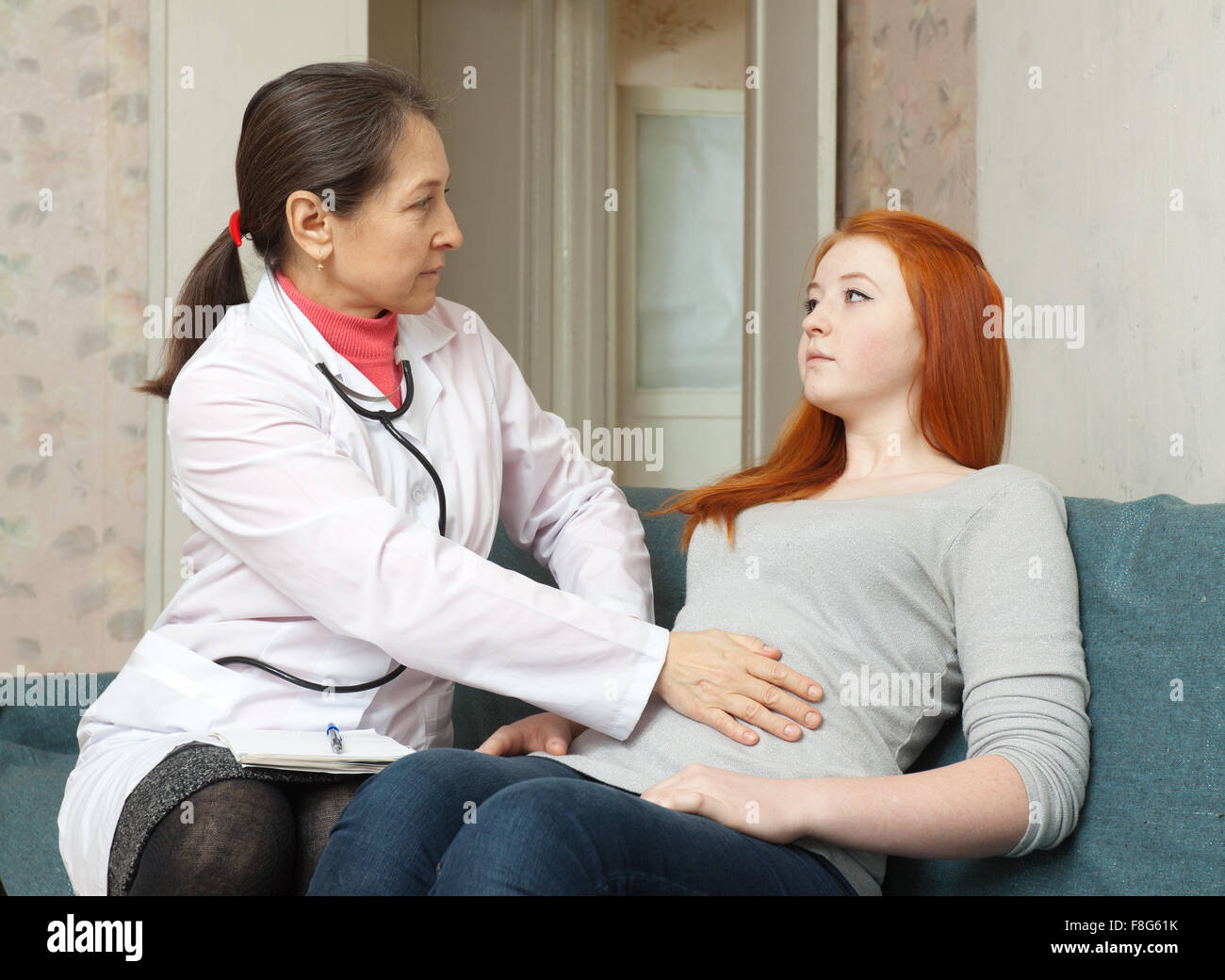 Doctor touching belly of teenager patient in interior Stock Photo - Alamy