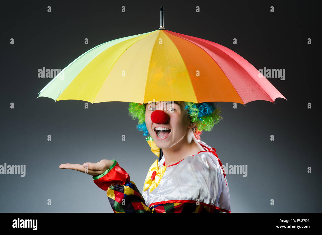 Funny clown with colourful umbrella Stock Photo - Alamy