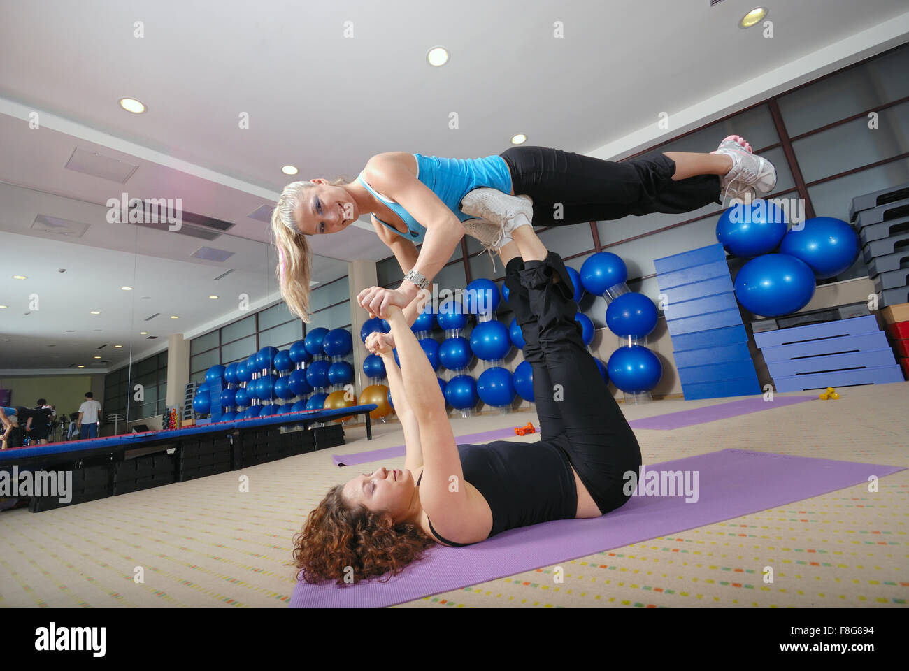 Coach and her gymnasts in the fitness Stock Photo - Alamy