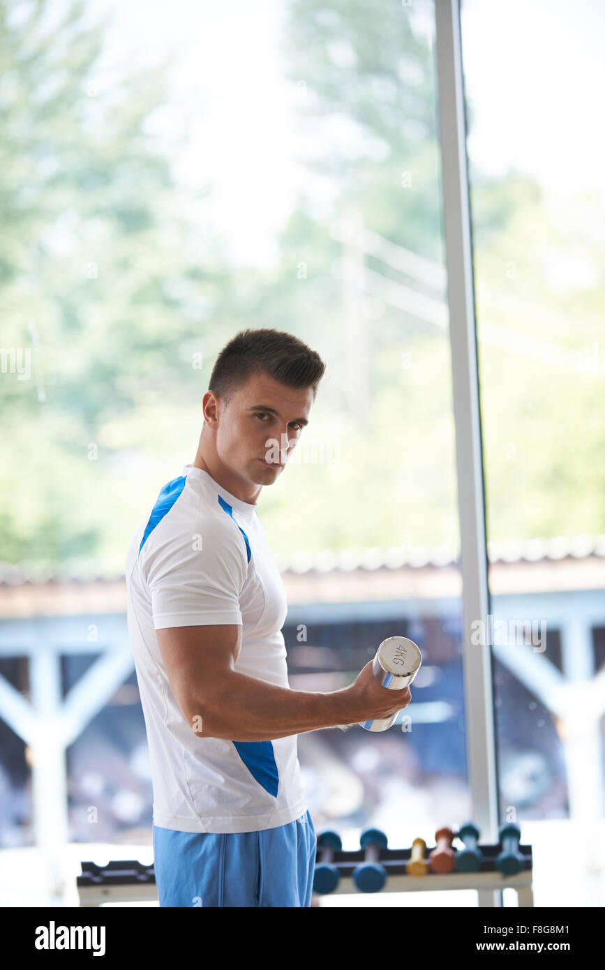 young man in fintess sport club exercise with weights and relaxing ...