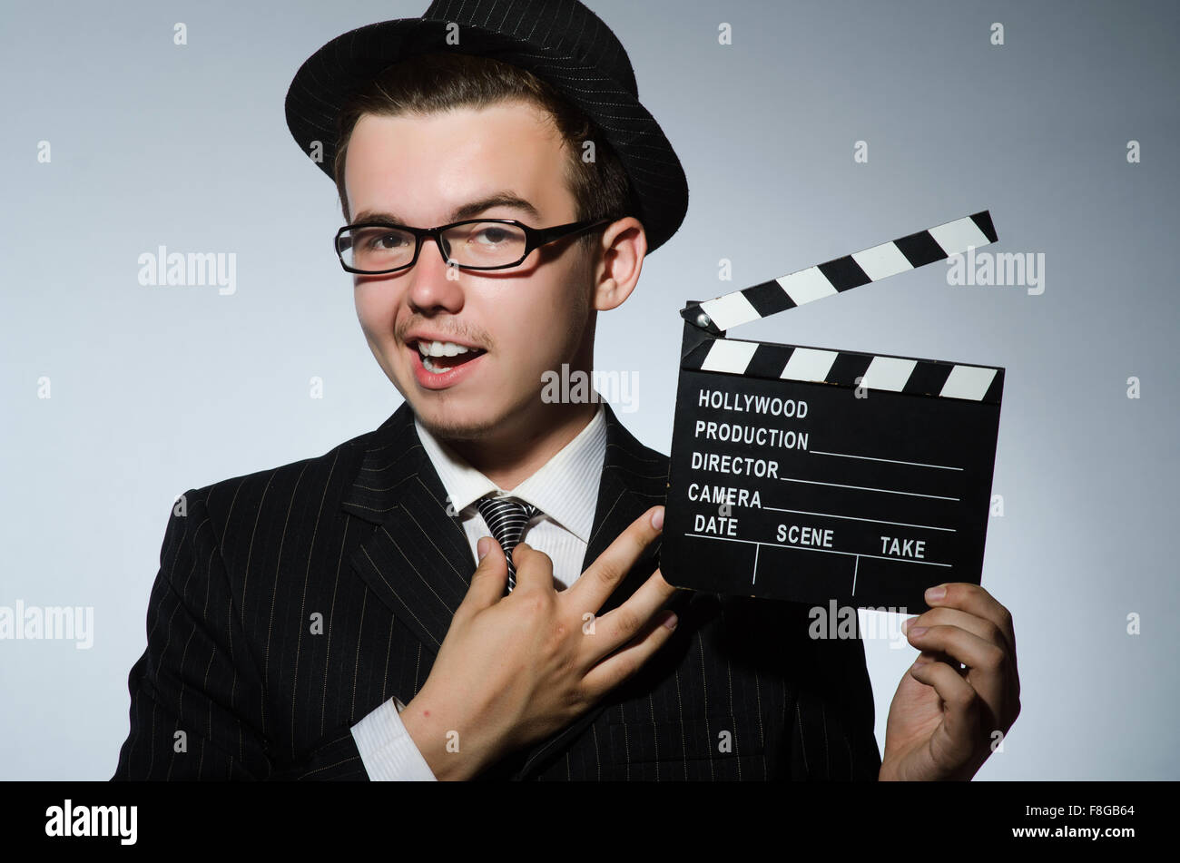 Man with movie clapperboard and hat Stock Photo - Alamy