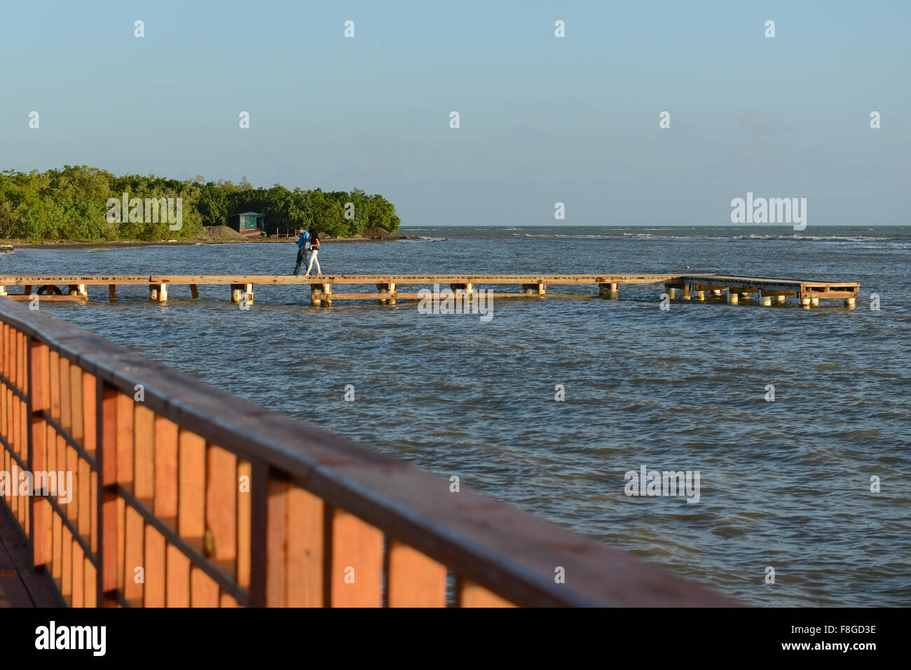 Couple walking along the pier. Juana Diaz, Puerto Rico. Caribbean ...