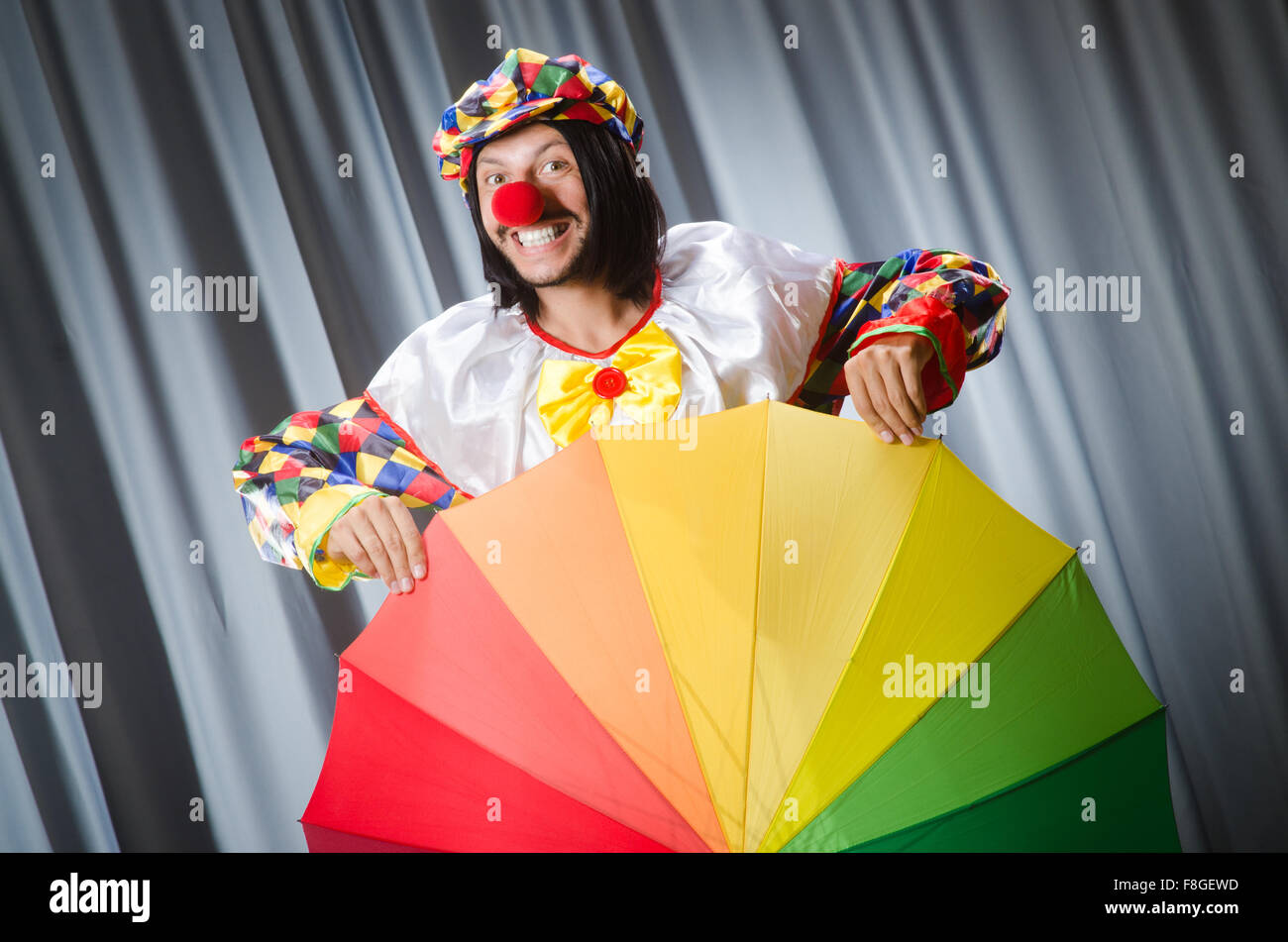 Funny clown with colourful umbrella Stock Photo - Alamy