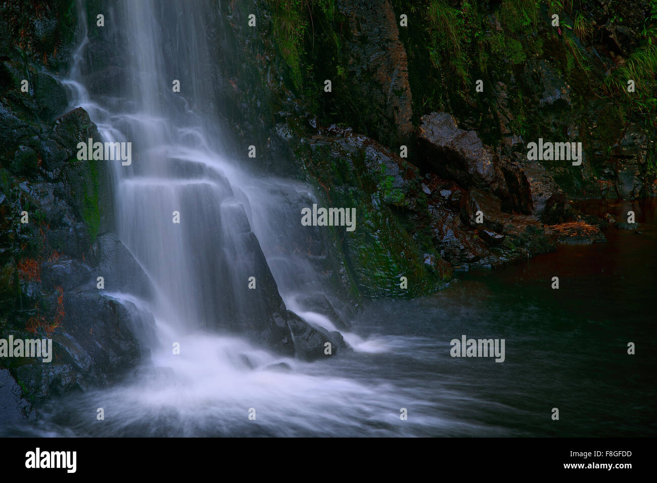 Waterfall flowing over rocky cliff Stock Photo - Alamy