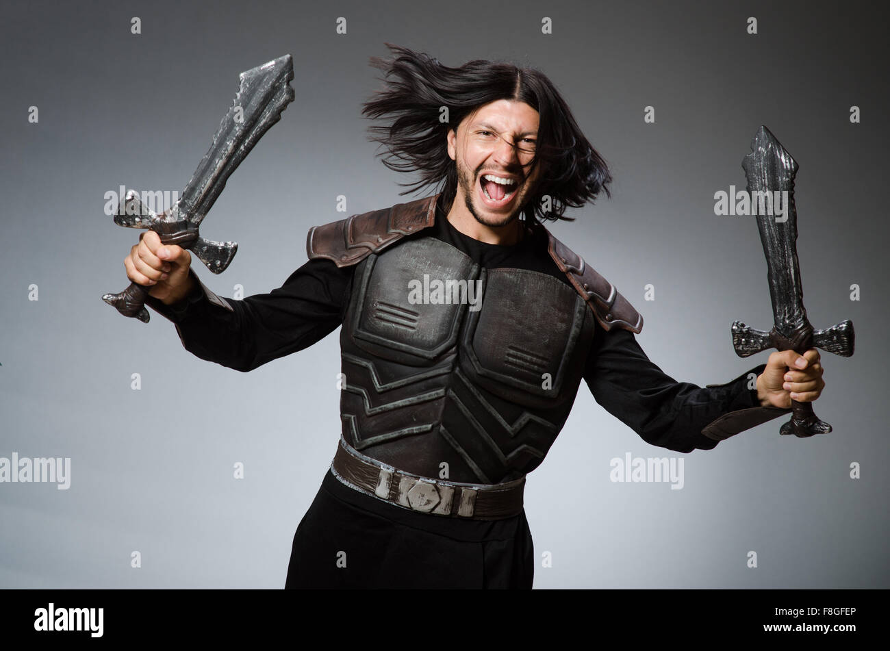Angry knight with sword against dark background Stock Photo - Alamy