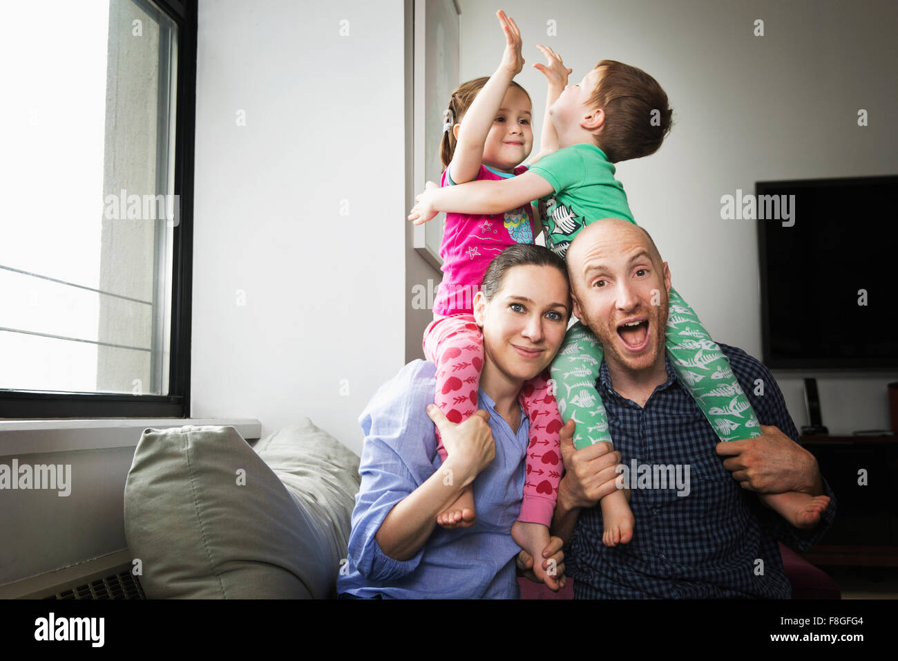 Parents carrying children on shoulders Stock Photo - Alamy