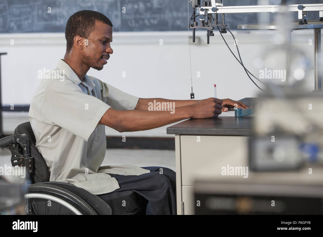 African American paraplegic student working in science classroom Stock ...