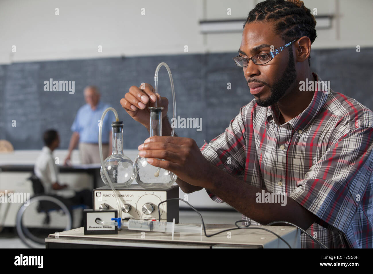 Student performing experiment in science classroom Stock Photo - Alamy