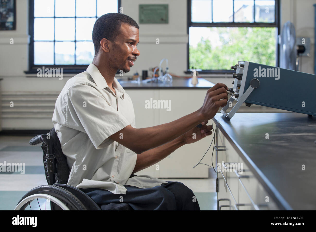 African American paraplegic student performing experiment in science ...